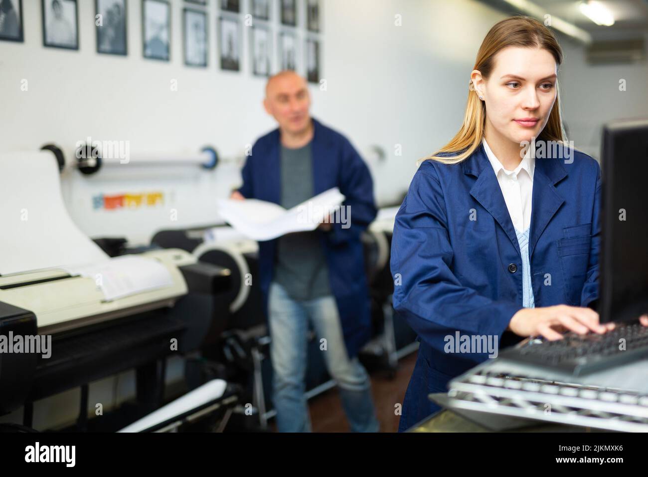 Technician operator calibrating plotter machine, typing on computer ...