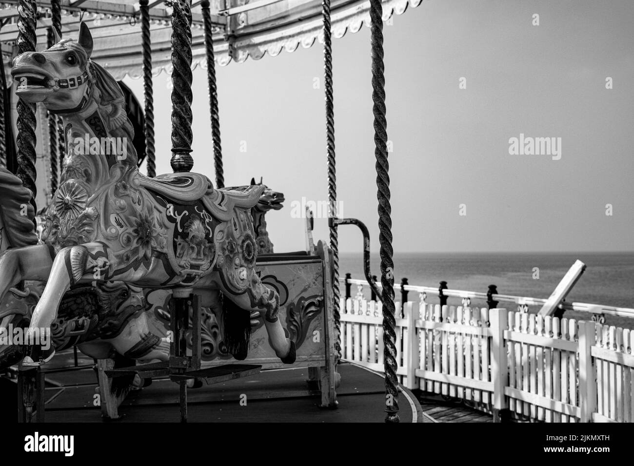 A grayscale shot of an Empty Merry-go-round ride on Brighton Pier by ...