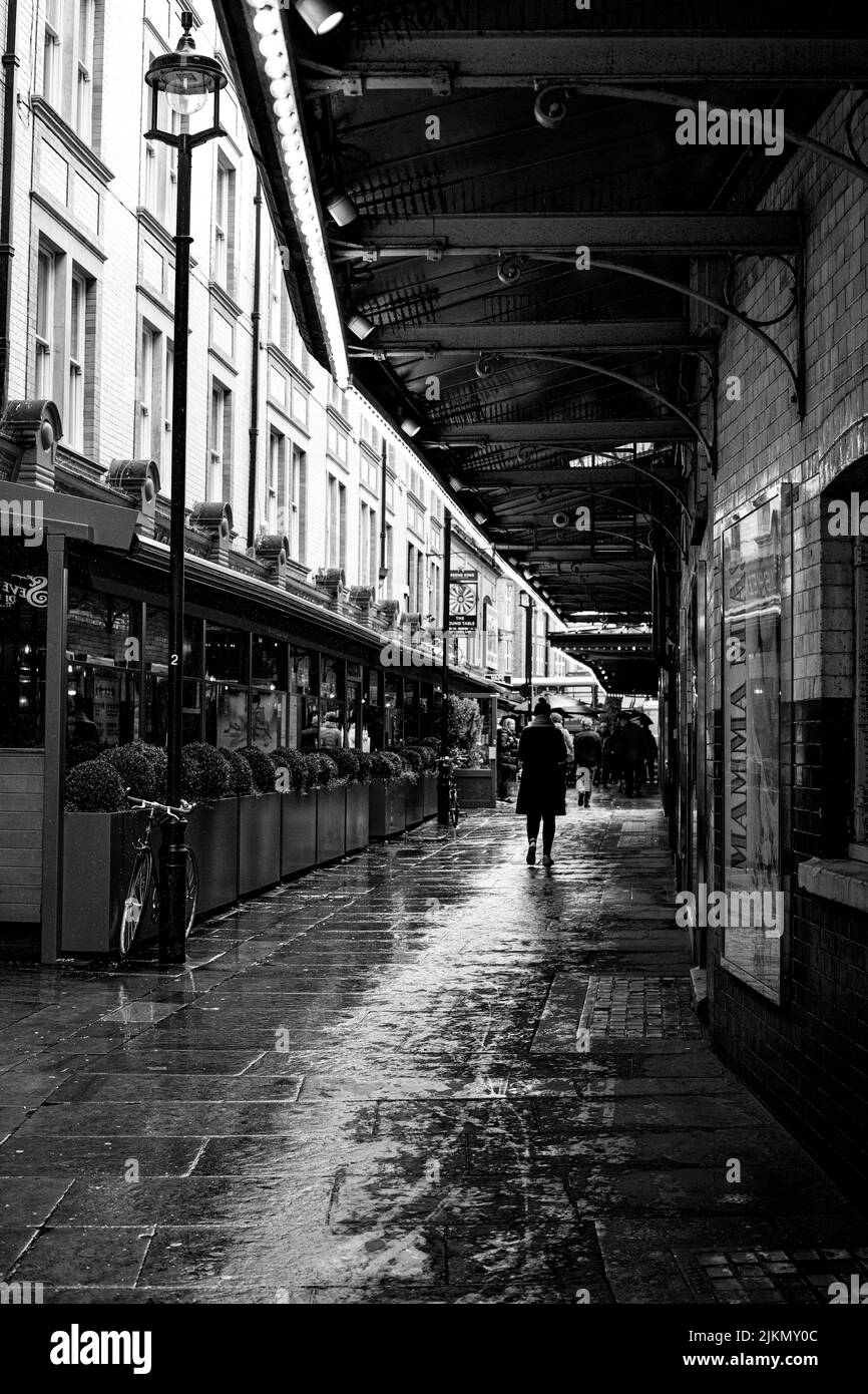 A grayscale shot of a Rainy London street next to a Theatre in London ...