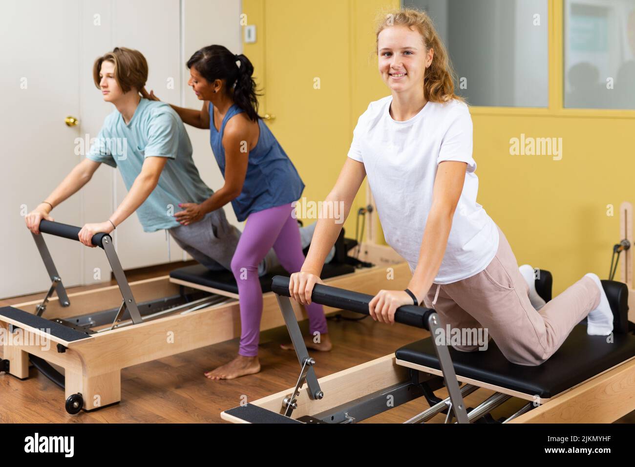Teens doing pilates exercises with trainer Stock Photo - Alamy