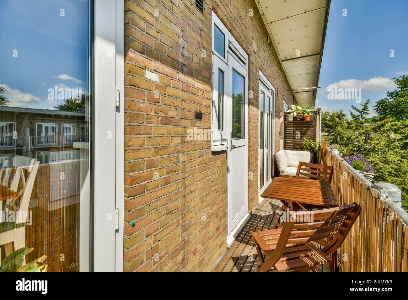 Narrow brick balcony with metal railings, wooden chair and door Stock ...
