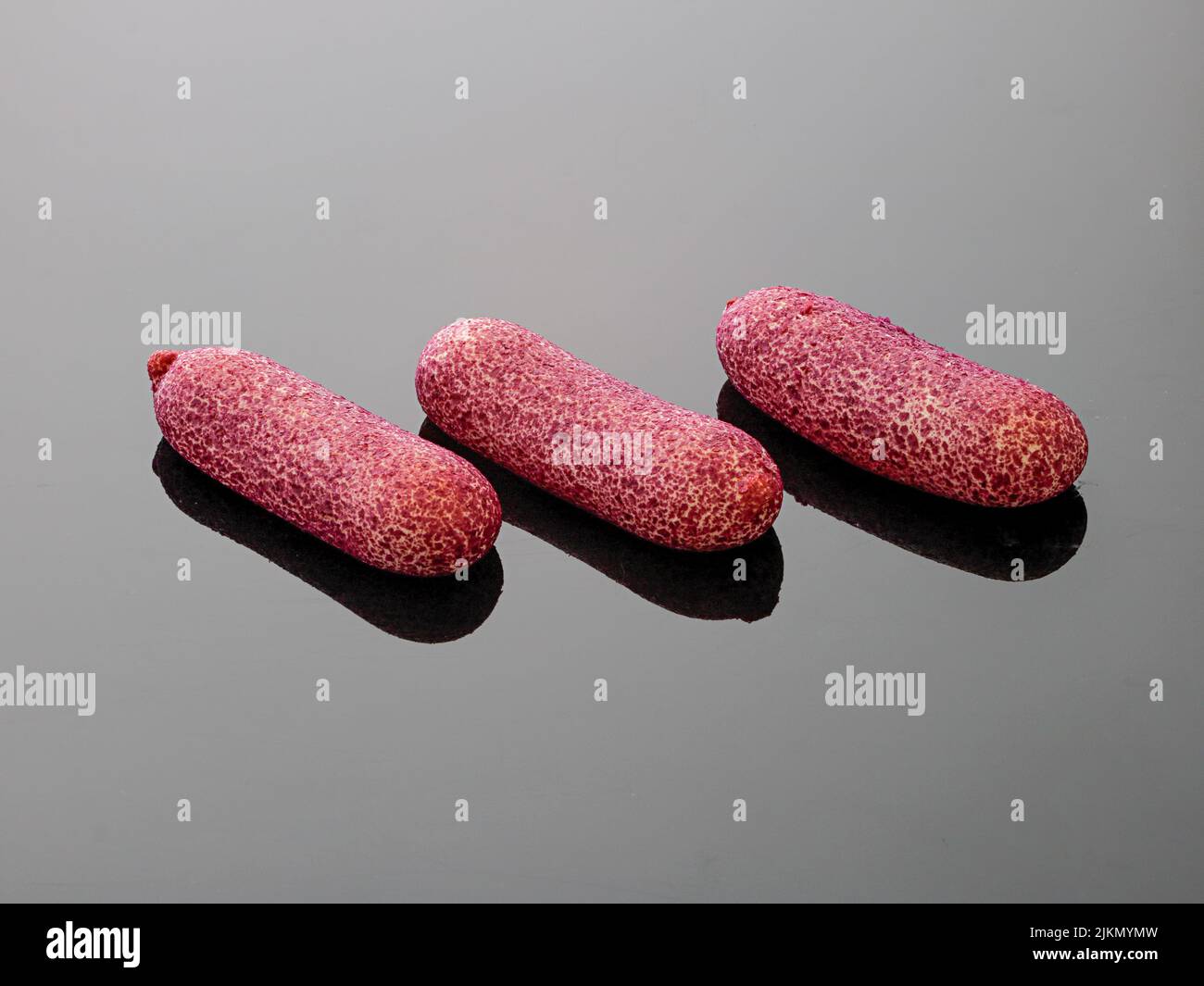 Three purple sticky rice rolls on a gray background Stock Photo - Alamy