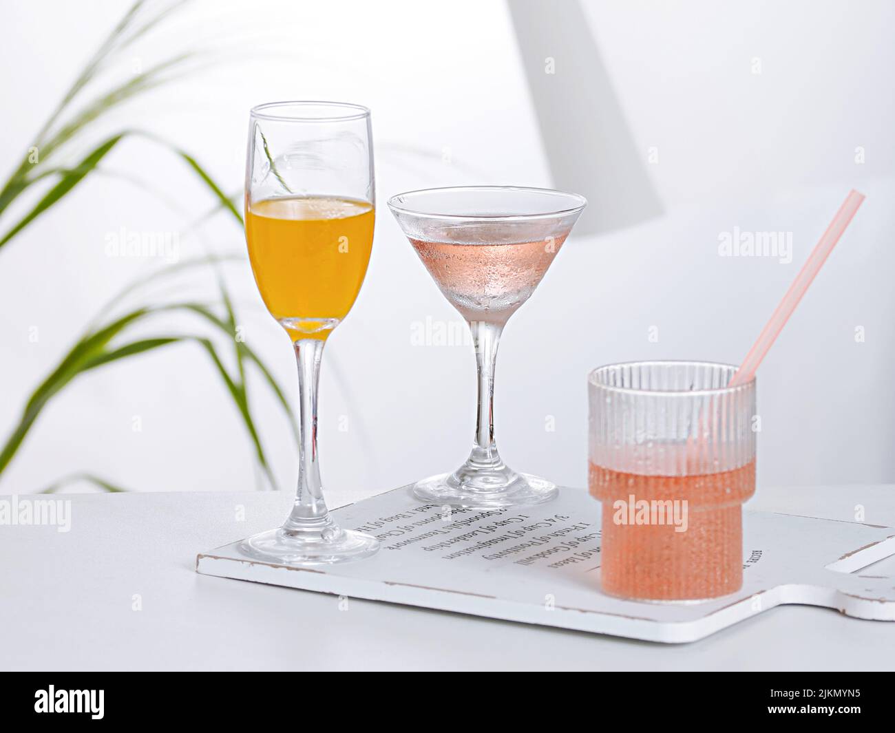 Three types of different cocktails on a cutting board on the table ...