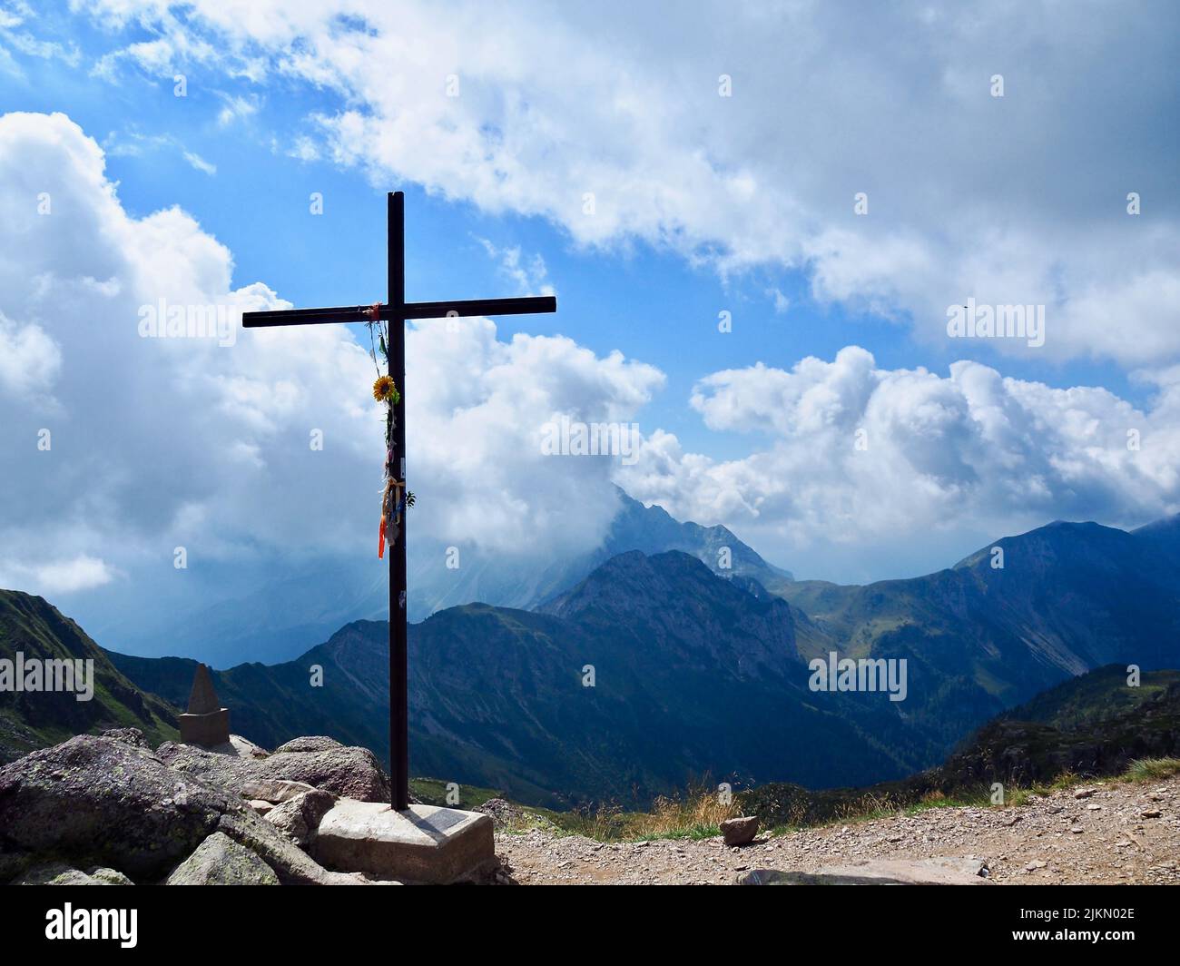 A cross with flowers on the top of the mountain Orobic Alps in the ...
