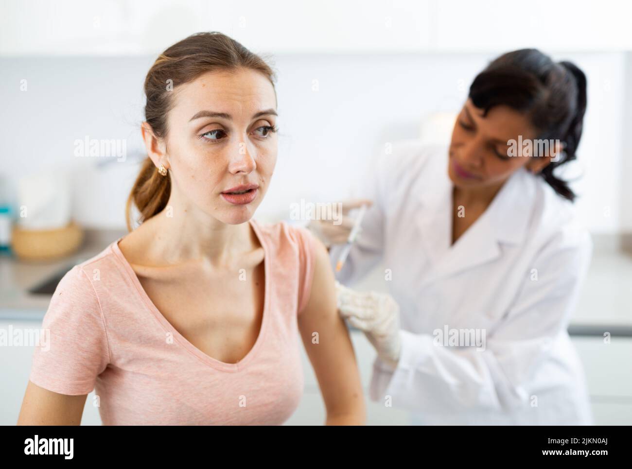 Woman client of medical clinic afraid of syringe Stock Photo - Alamy