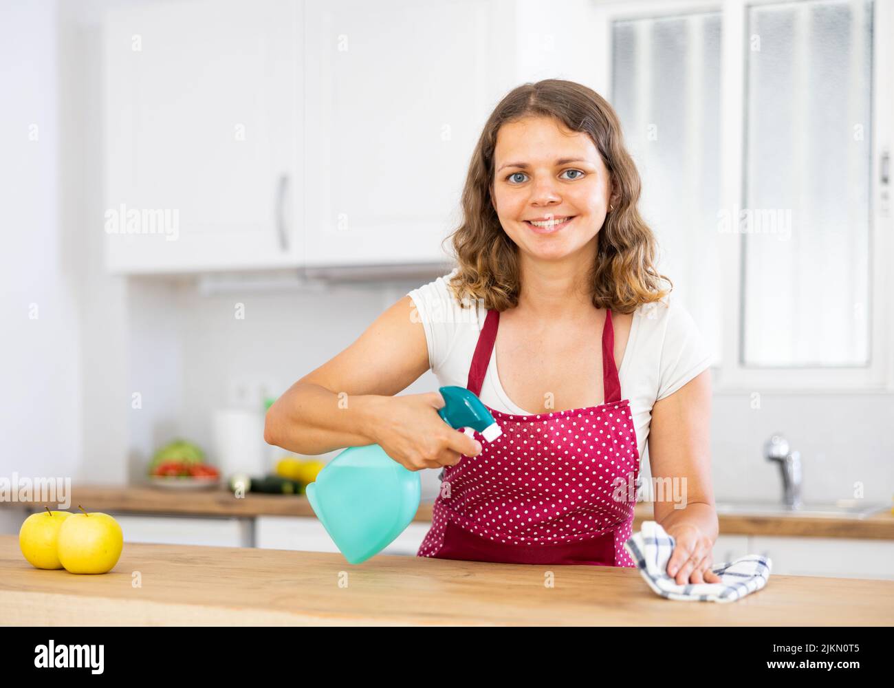 Young woman cleaning kitchen countertop at home Stock Photo - Alamy