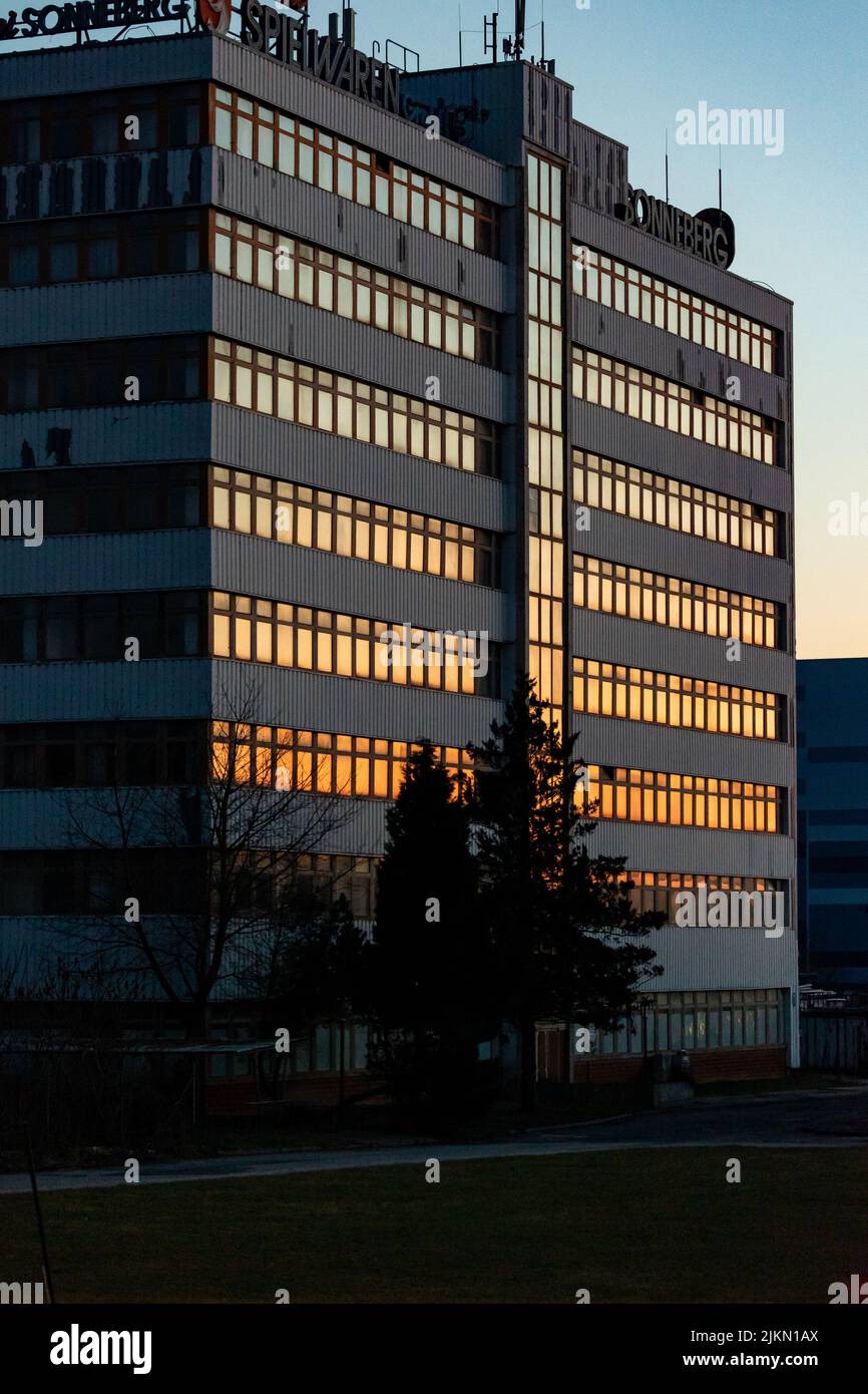 A vertical shot of a glass-walled building with a reflection of the ...