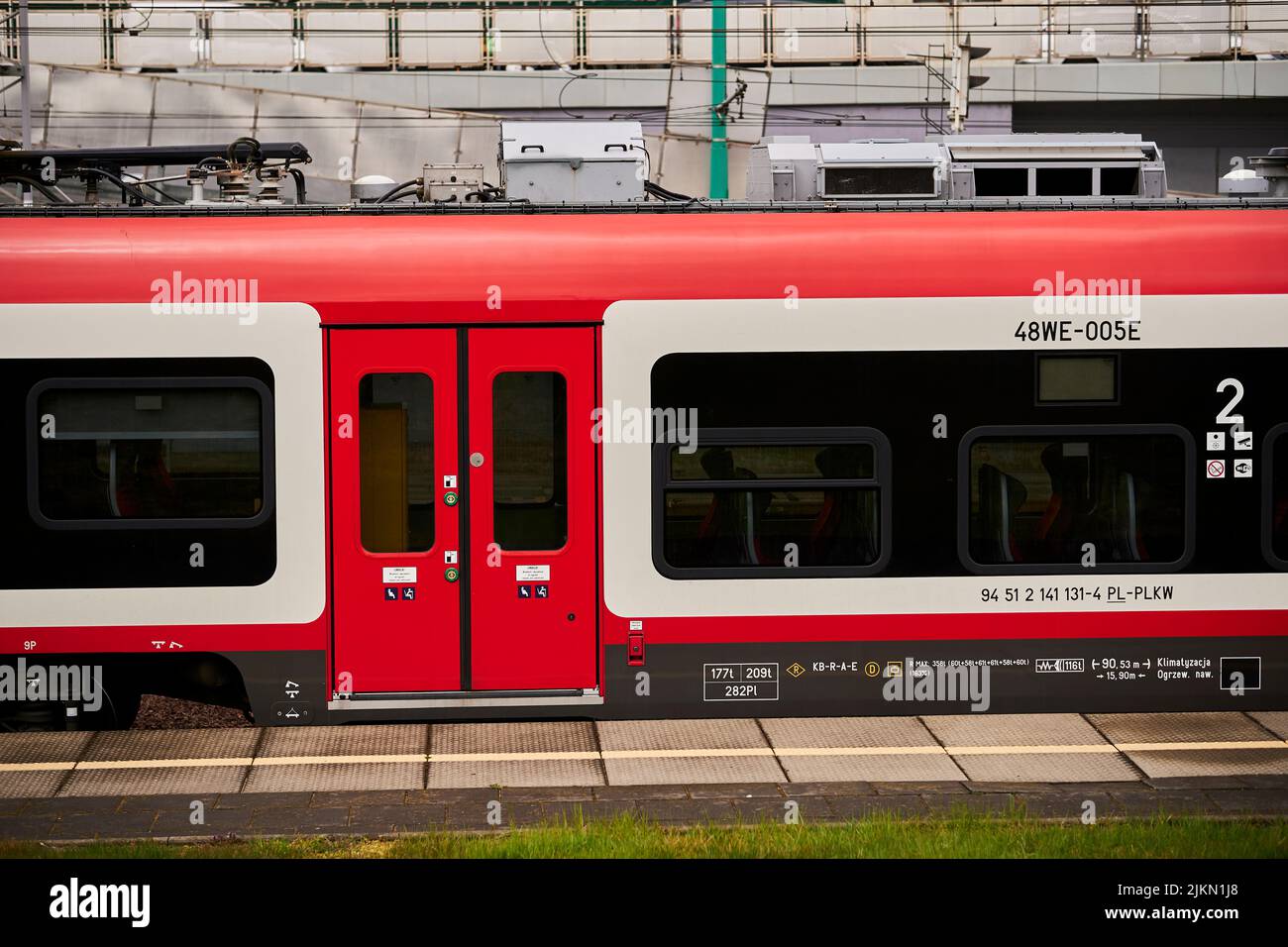 The doors of a waiting red electric train at a station in the city ...