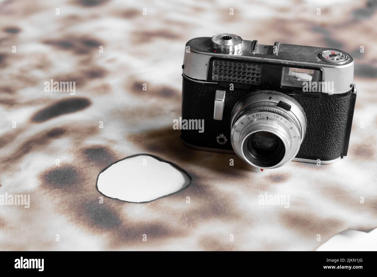 A closeup of a vintage camera on a white background with the burnt ...