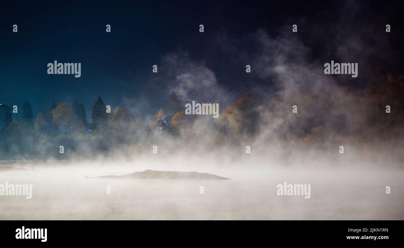 A scenic view of an autumn forest through the fog above the water Stock ...