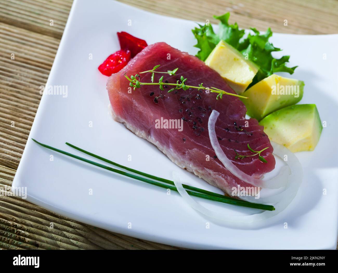 Delicious pieces raw tuna, green avocado and greens at plate Stock ...