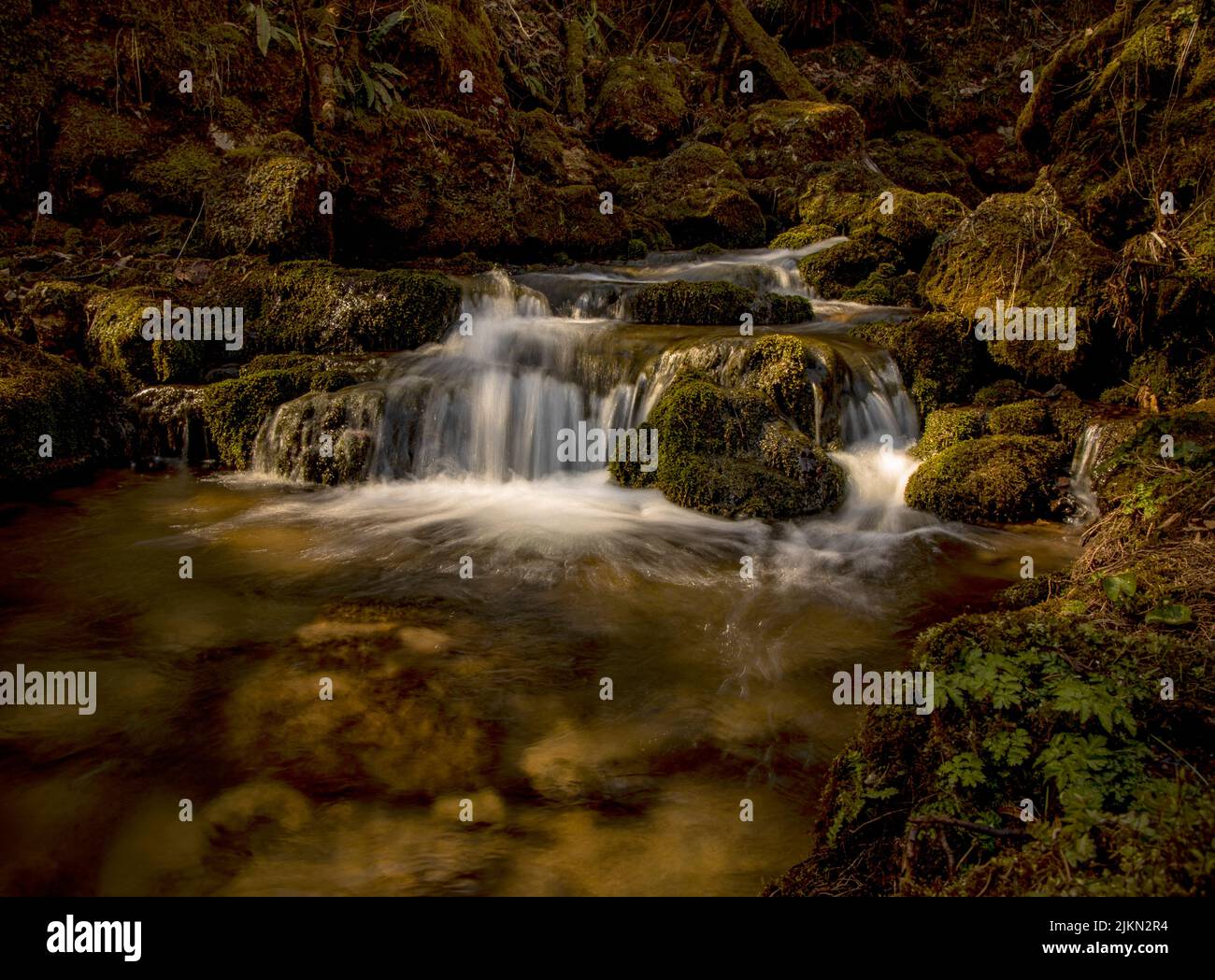 A waterfall flowing over the rocks Stock Photo - Alamy