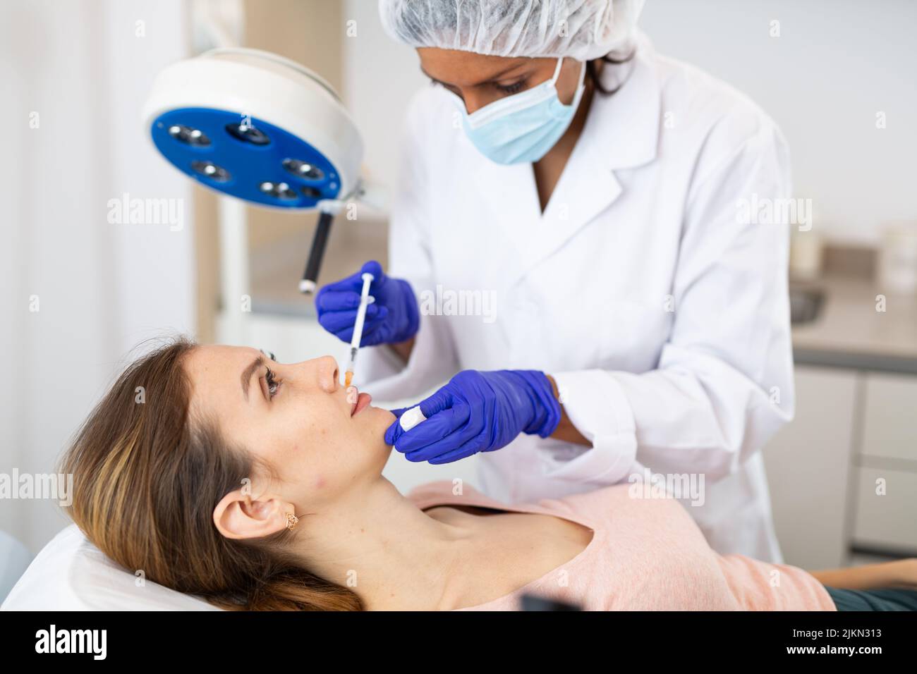 Female patient getting beauty injection for lips Stock Photo - Alamy