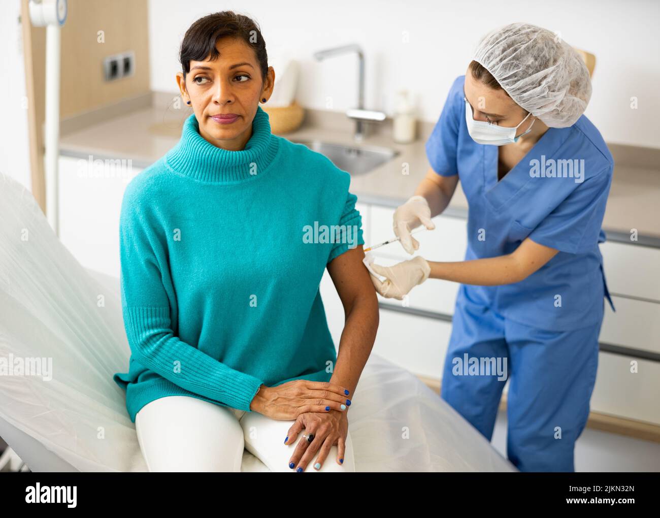 Adult woman getting injection at doctors office Stock Photo - Alamy