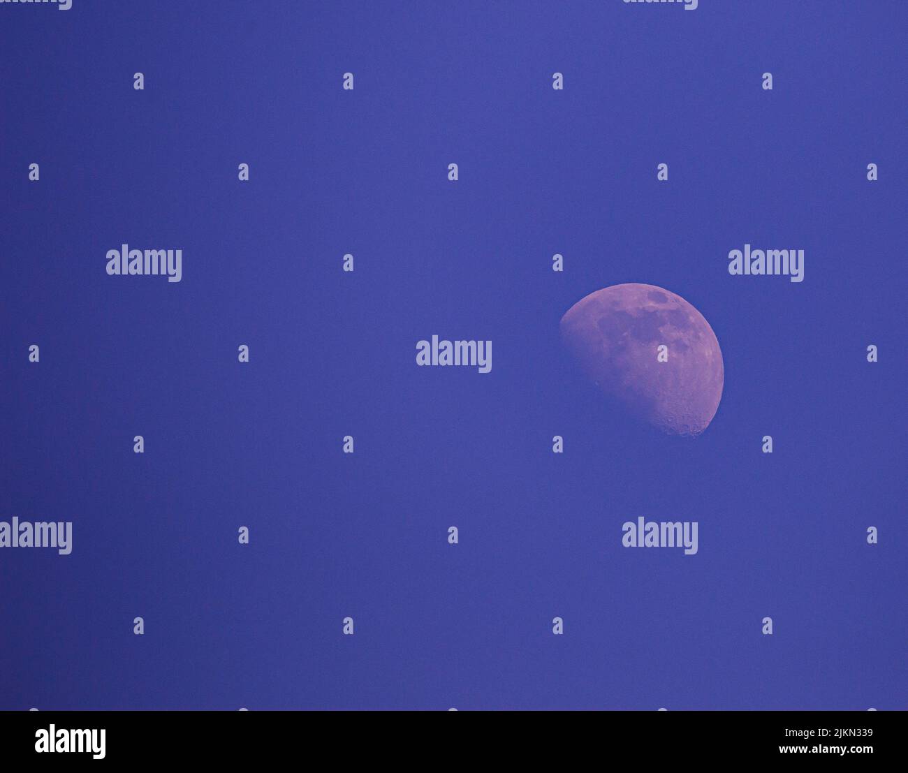 A closeup of a translucent moon in the purple colored sky Stock Photo ...