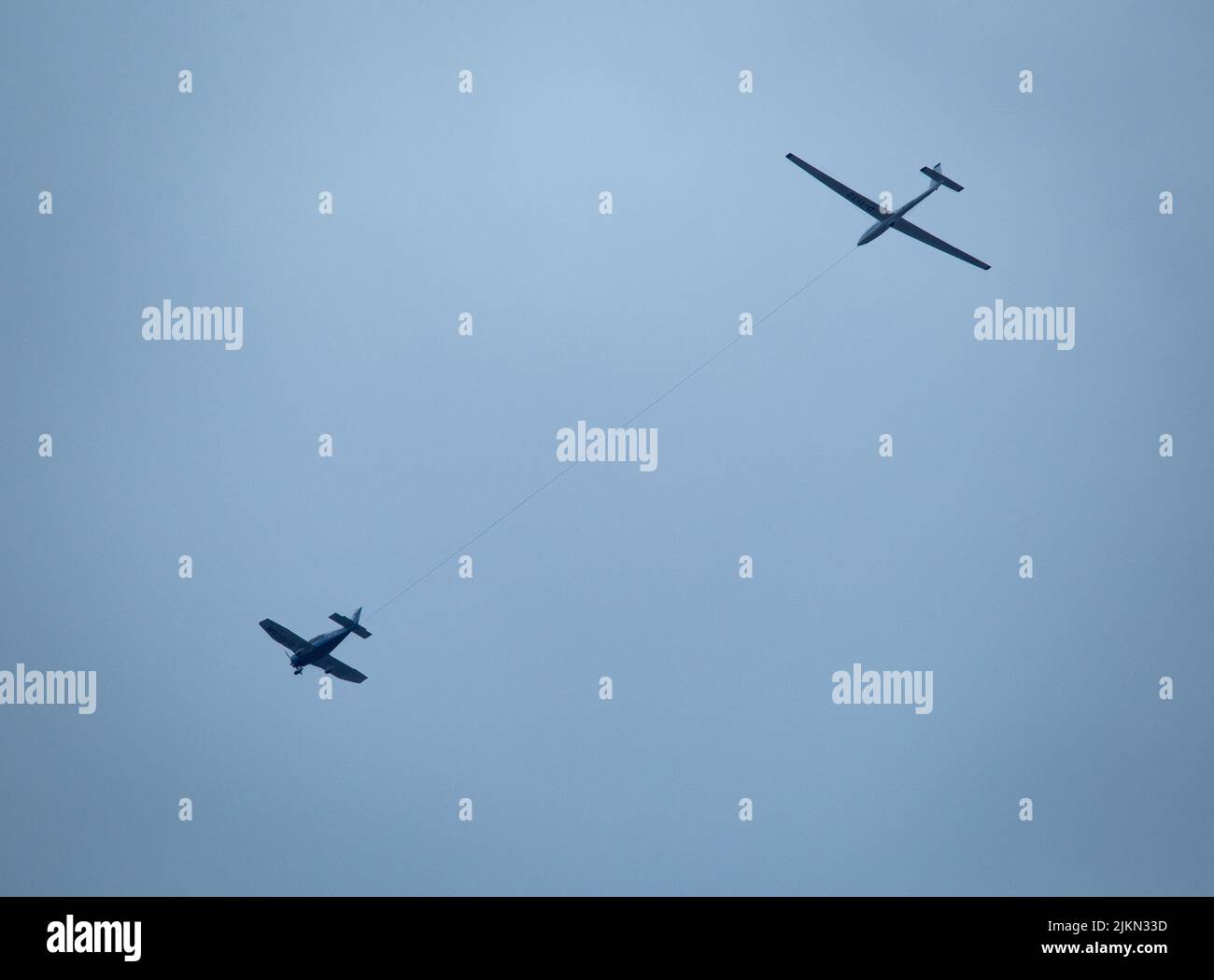 The two planes connected with a rope flying in the blue sky Stock Photo ...