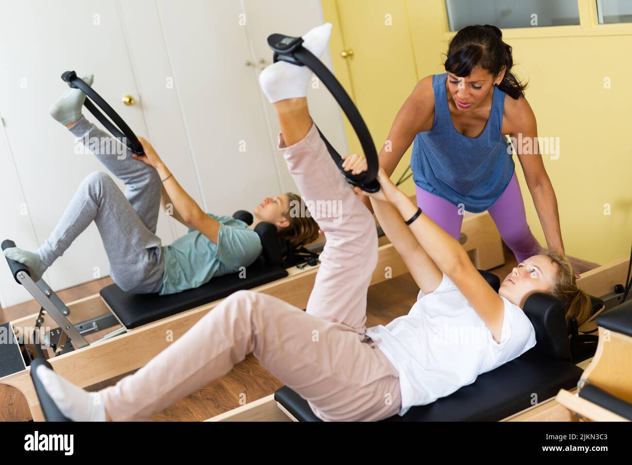 Teens training in pilates lessons led by female trainer Stock Photo - Alamy