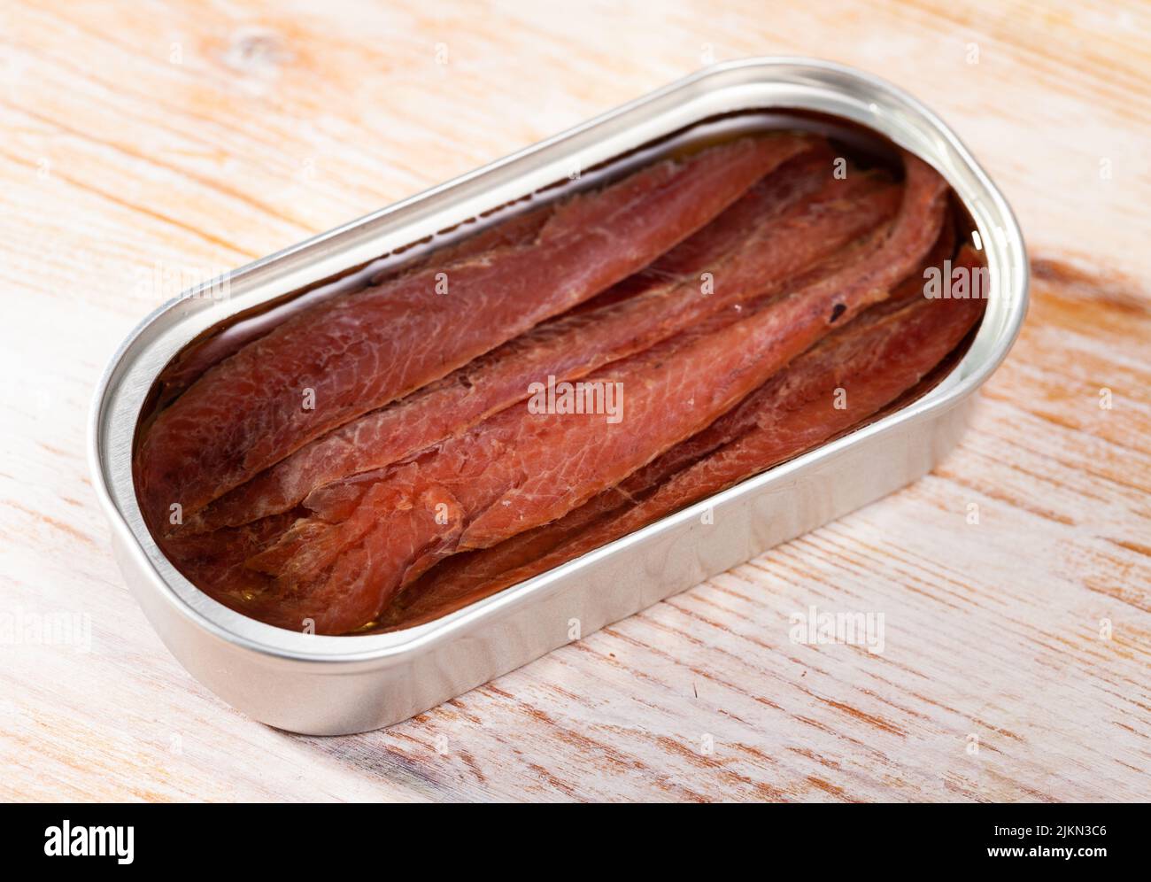 Tasty preserved anchovy fillet in oil on wooden surface, nobody Stock ...
