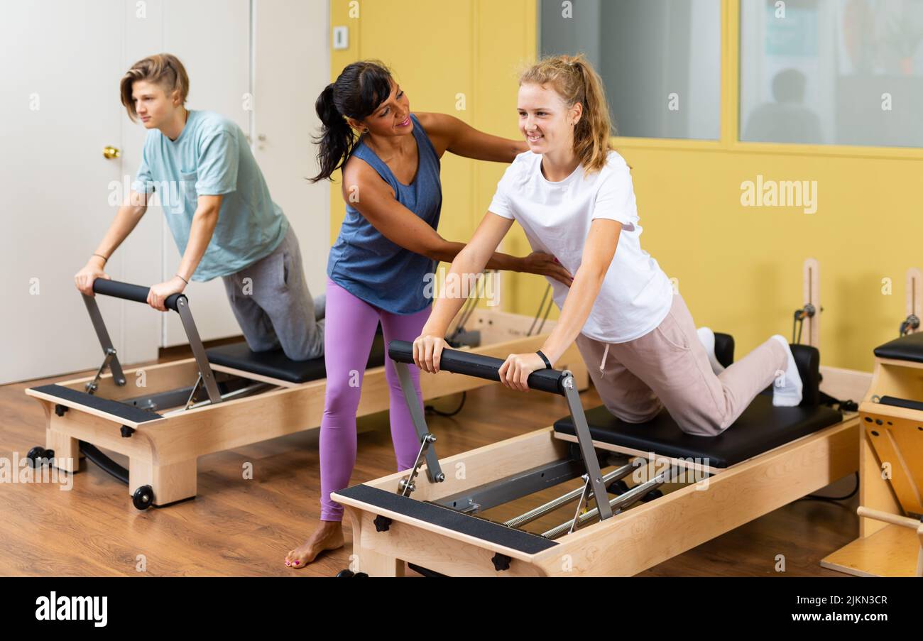 Pilates instructor helps and monitors the difficulty of Pilates ...