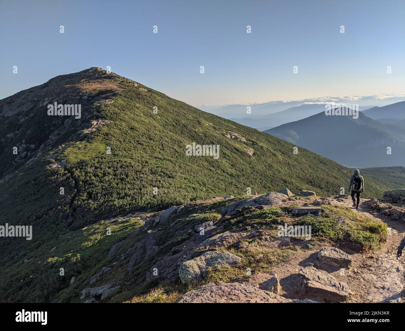 A natural landscape view of the hill and a hiker reaching the top Stock ...