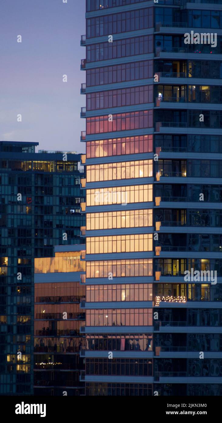 A vertical shot of a tall skyscraper with glass windows at sunset Stock ...