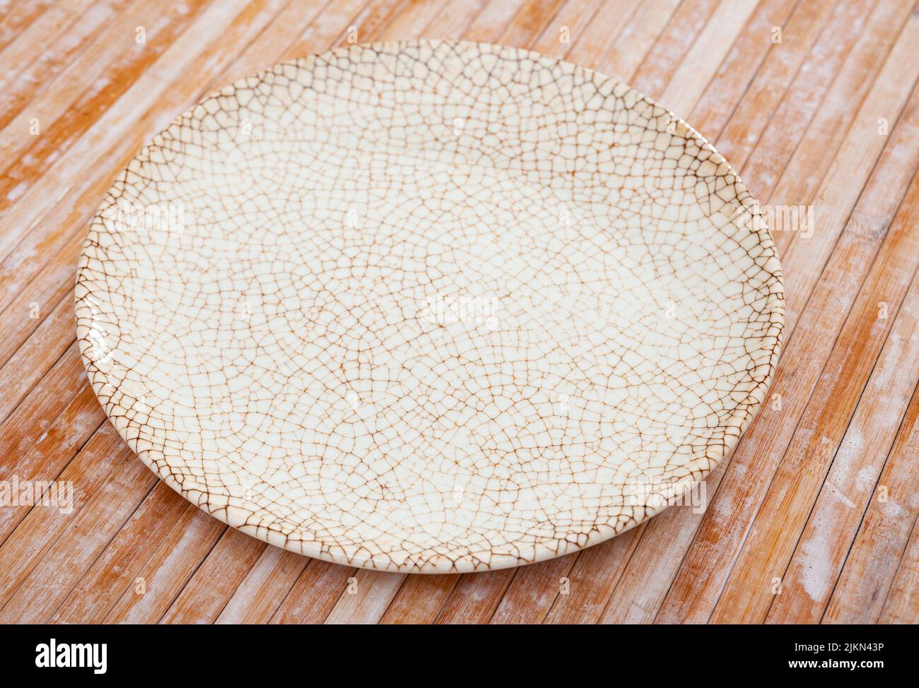 Empty hand-crafted ceramic plate on wooden table surface Stock Photo ...