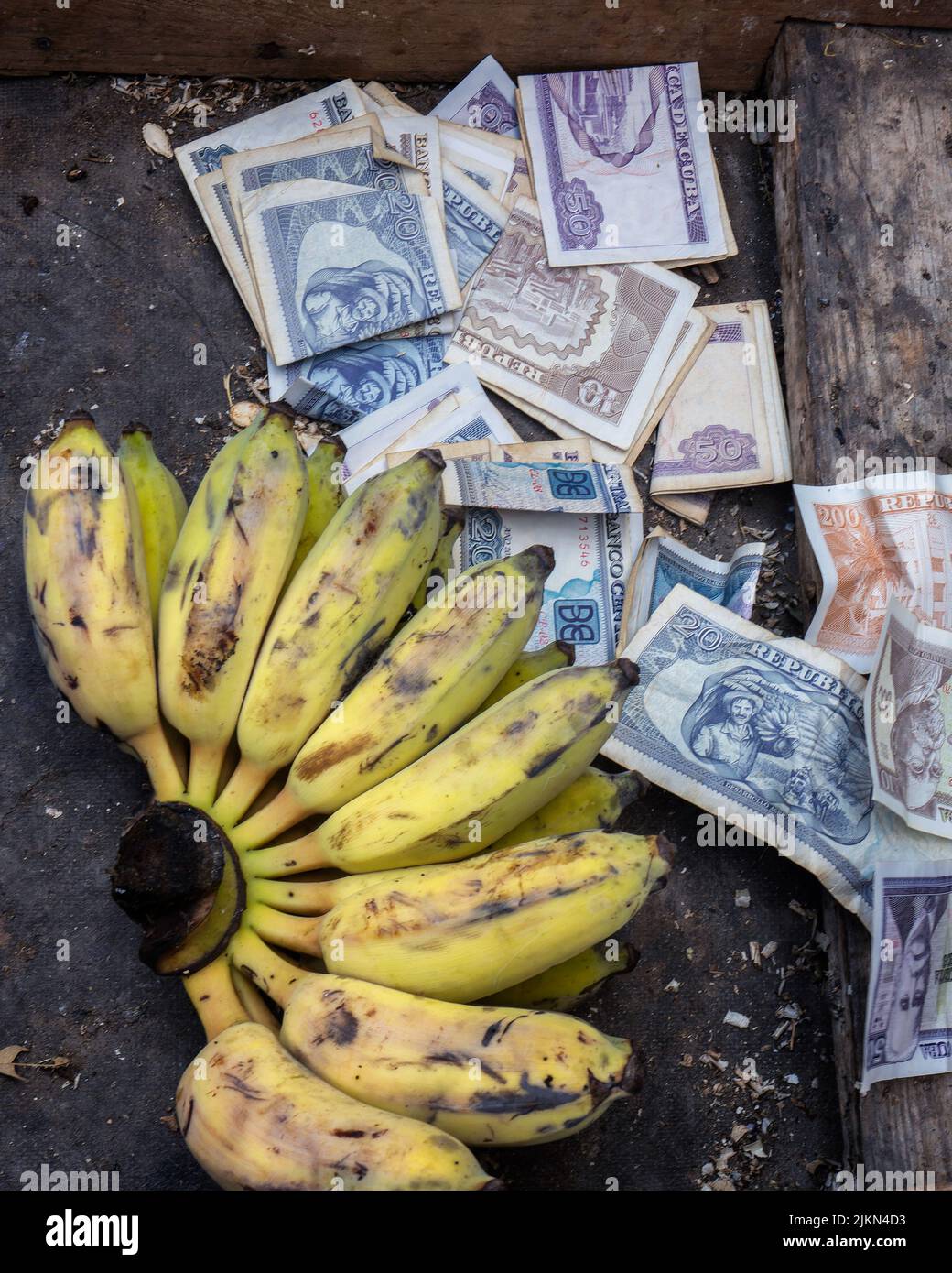 A top view of a banana bunch and Cuban peso bills Stock Photo - Alamy