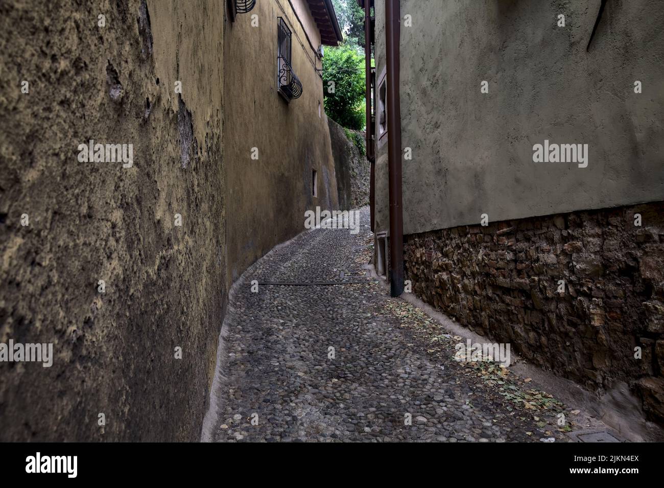 Very narrow cobbled alley in an italian town Stock Photo - Alamy