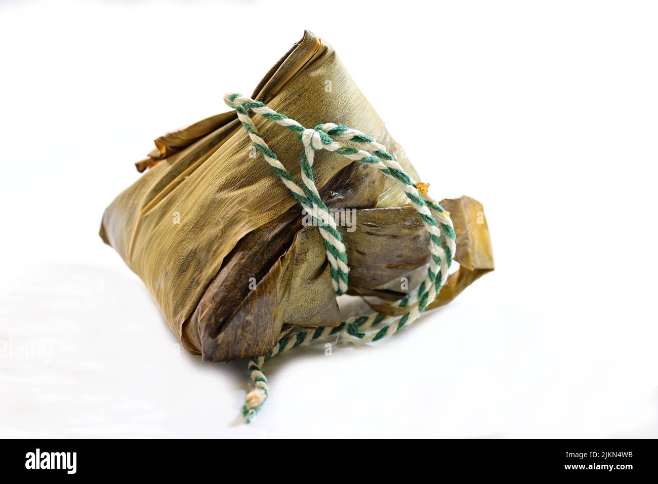 A Chinese sticky rice dumpling, zongzi or bakcang, wrapped in bamboo ...