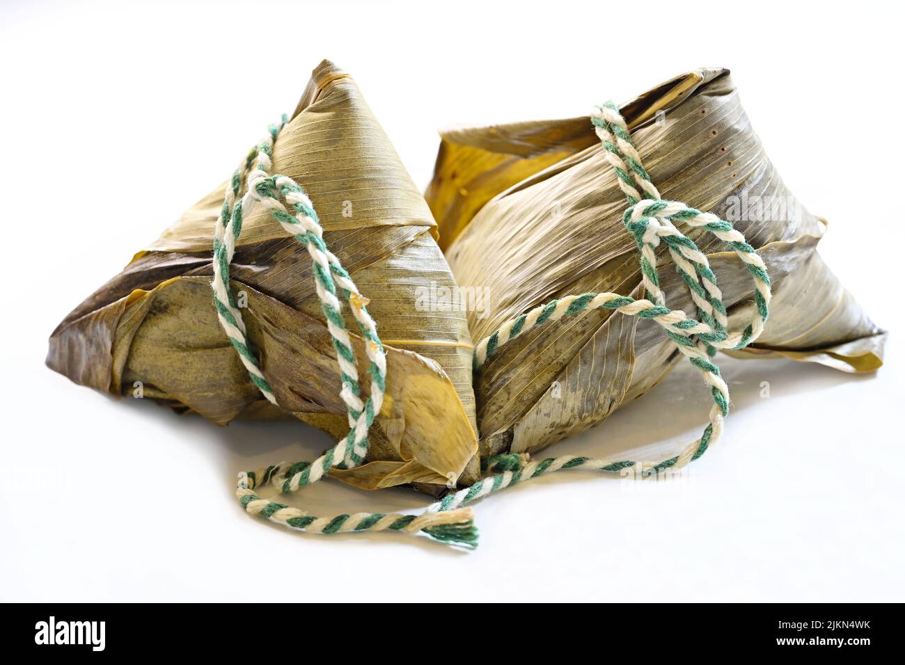 Two Chinese sticky rice dumplings, zongzi or bakcang, wrapped in bamboo ...