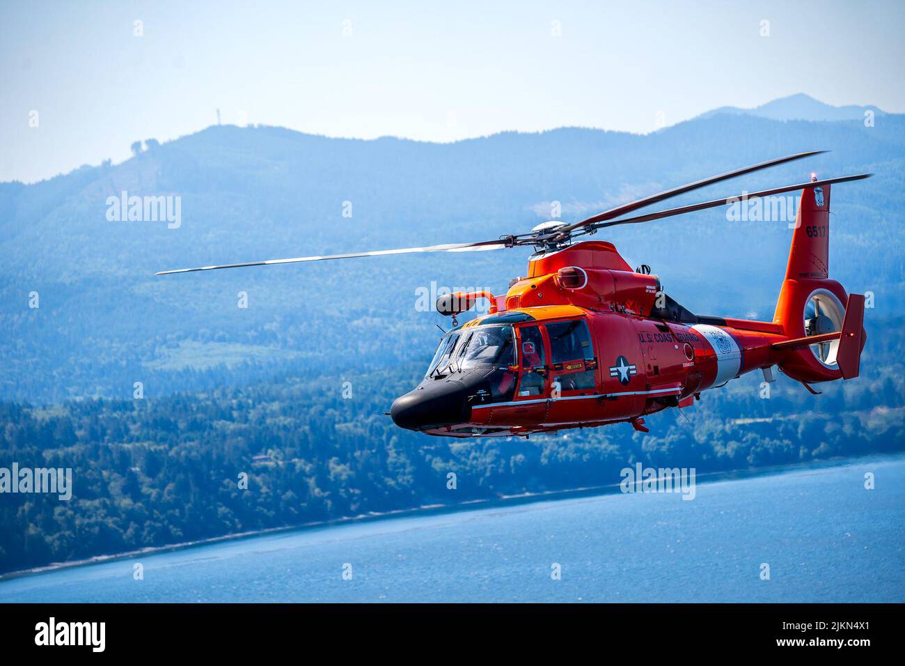 An MH-65 Dolphin helicopter aircrew conducts a formation flight over ...