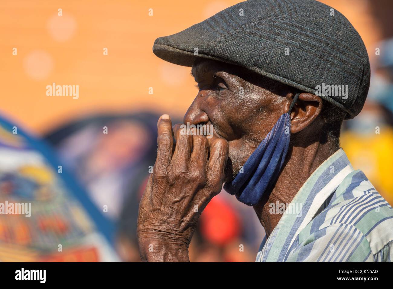 A selective focus shot of an old Cuban male with his hand on his mouth ...