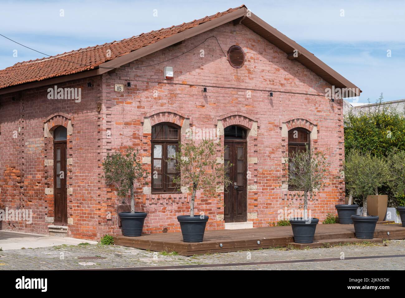A pink rustic brick house on the Alcantara dock in Lisbon, Portugal ...