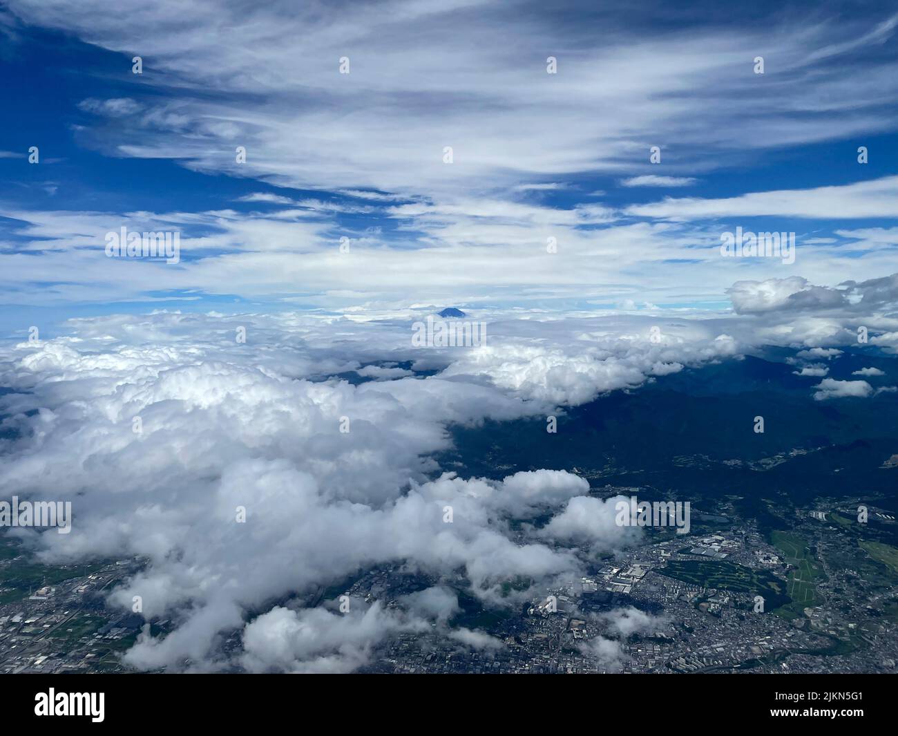 Mt. Fuji peeks above the clouds during a C-130J formation flight in the ...