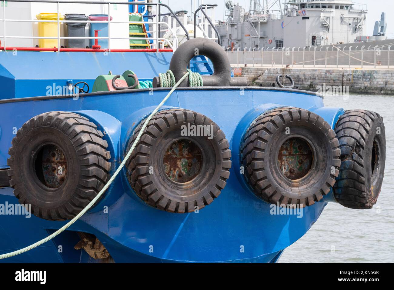 A huge blue tugboat in the dock, designed to push pull and tow barges ...