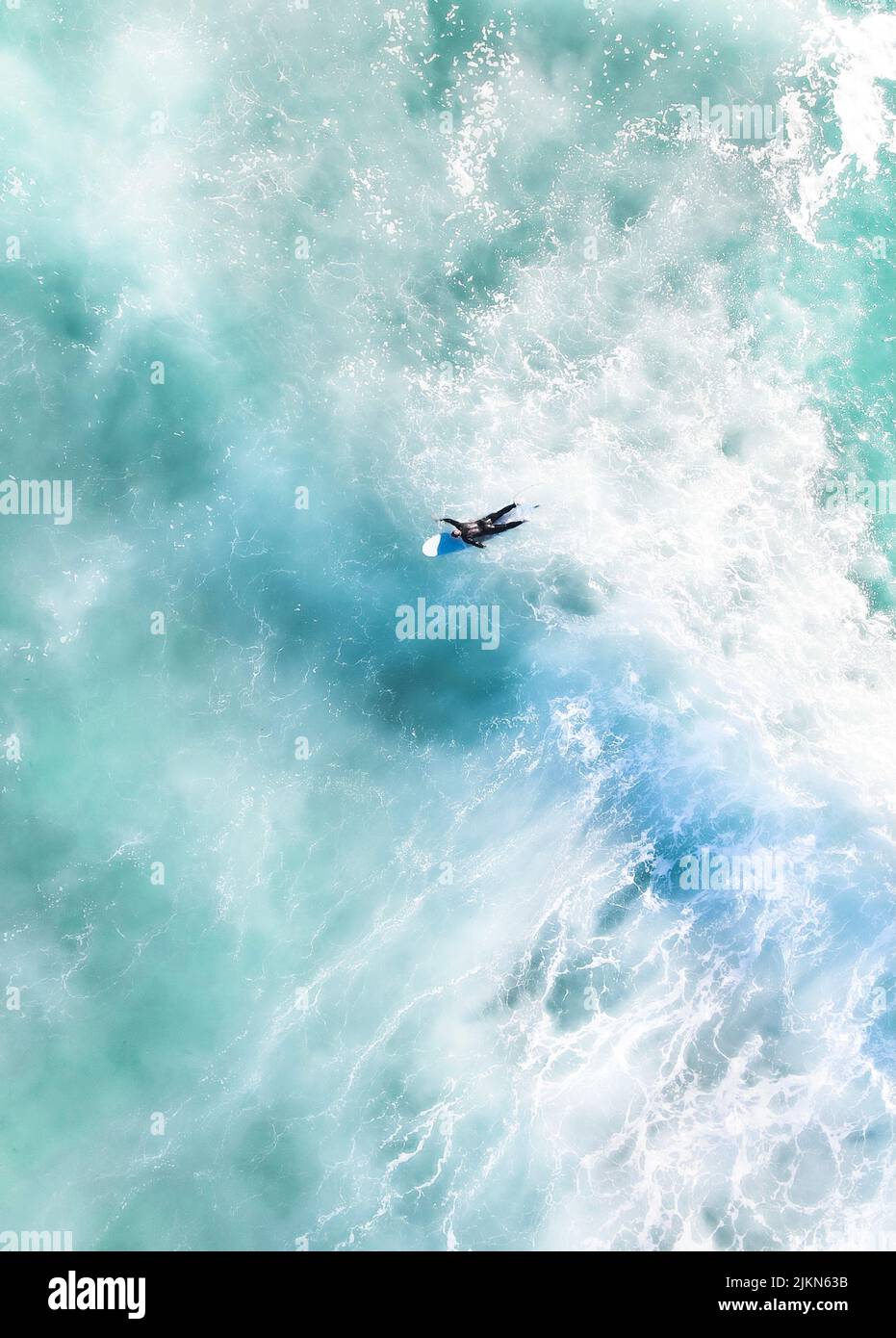 A vertical aerial top view of a surfer at Bondi Beach, Sydney ...