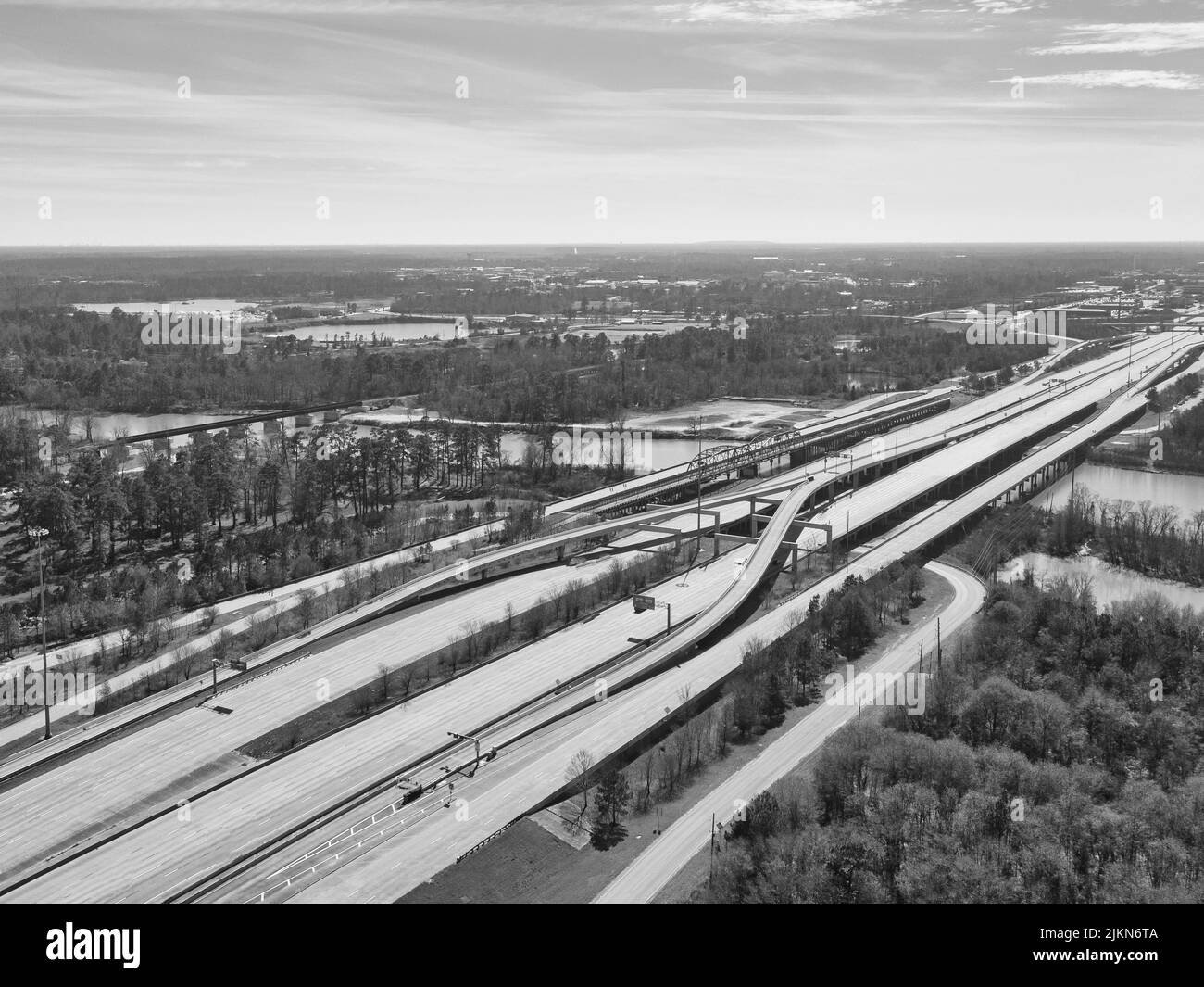 An aerial grayscale view of a bridge covered with snow over the lake ...