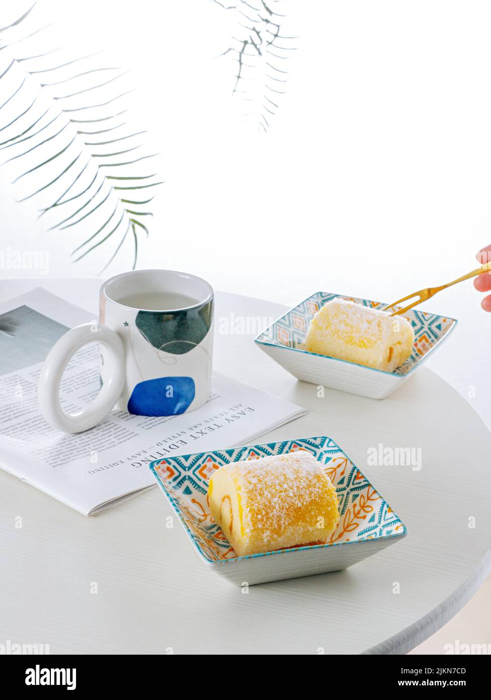 A vertical shot of aesthetic table setup with swiss roll dessert and a ...