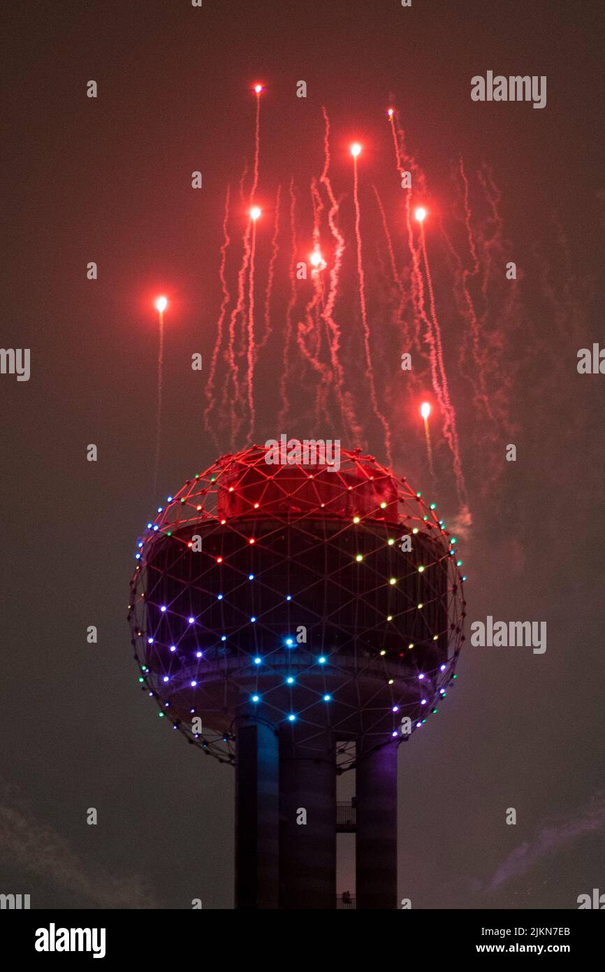 A vertical view of colorful fireworks exploding above the Reunion Tower ...