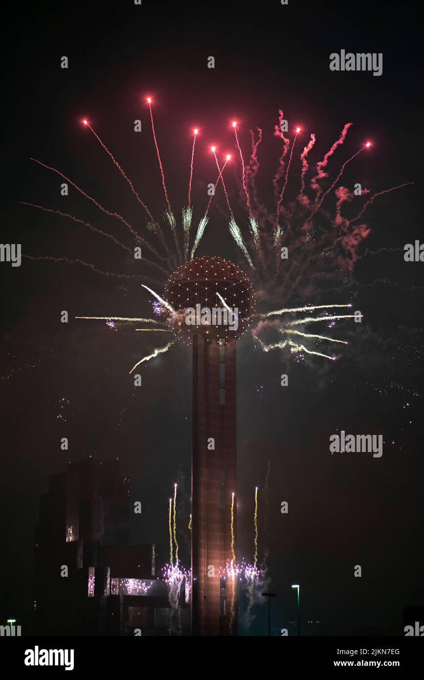 A vertical view of colorful fireworks exploding above the Reunion Tower in Dallas, Texas on New ...