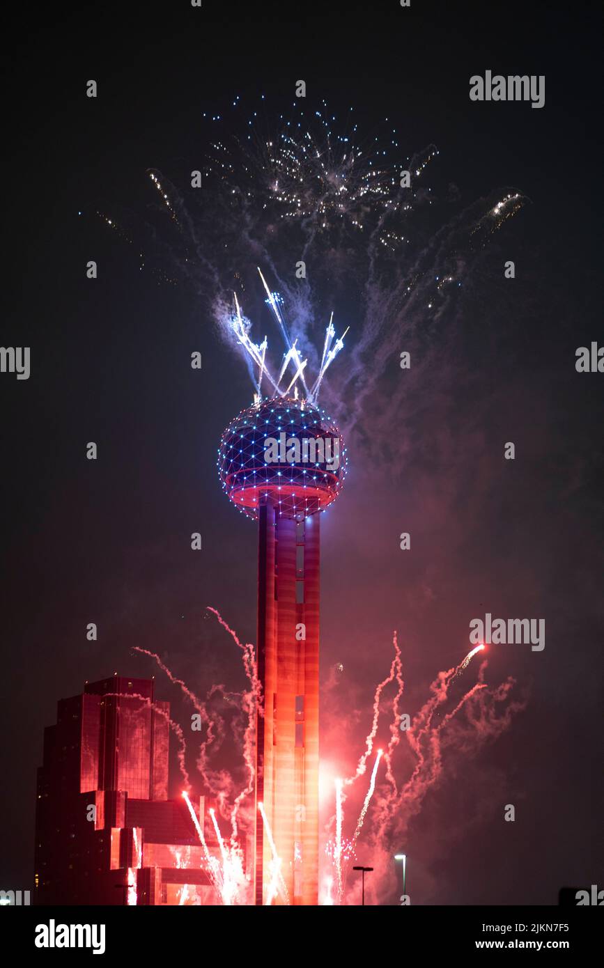 A vertical view of colorful fireworks exploding above the Reunion Tower in Dallas, Texas on New ...