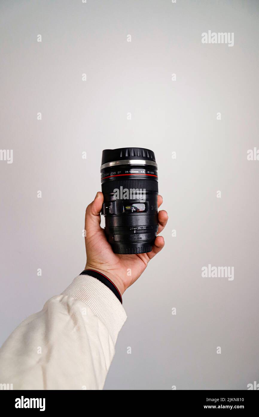 A vertical closeup of the hand holding camera lens Stock Photo - Alamy