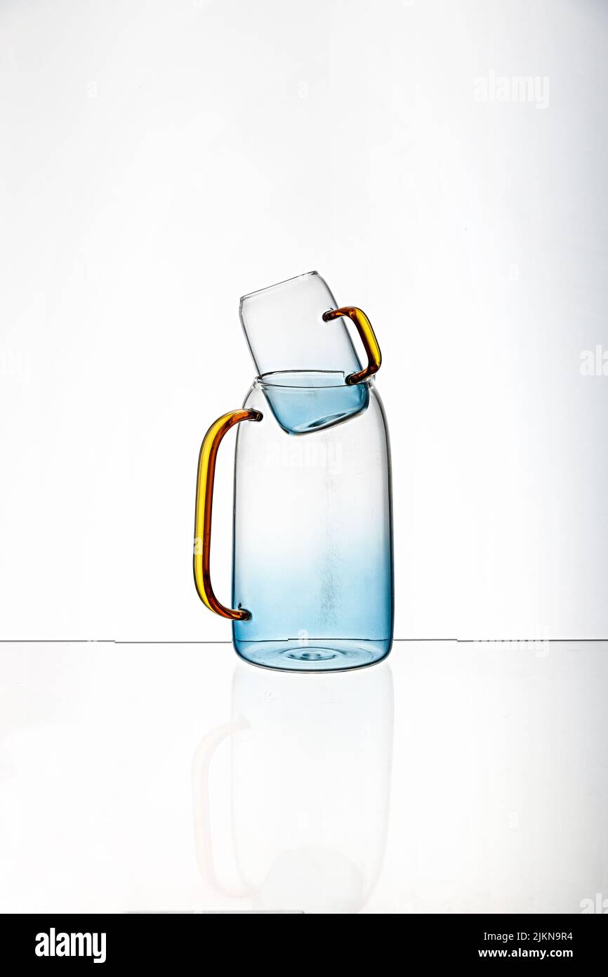 The vertical shot of a glass blue transparent cups and juice pot with a ...