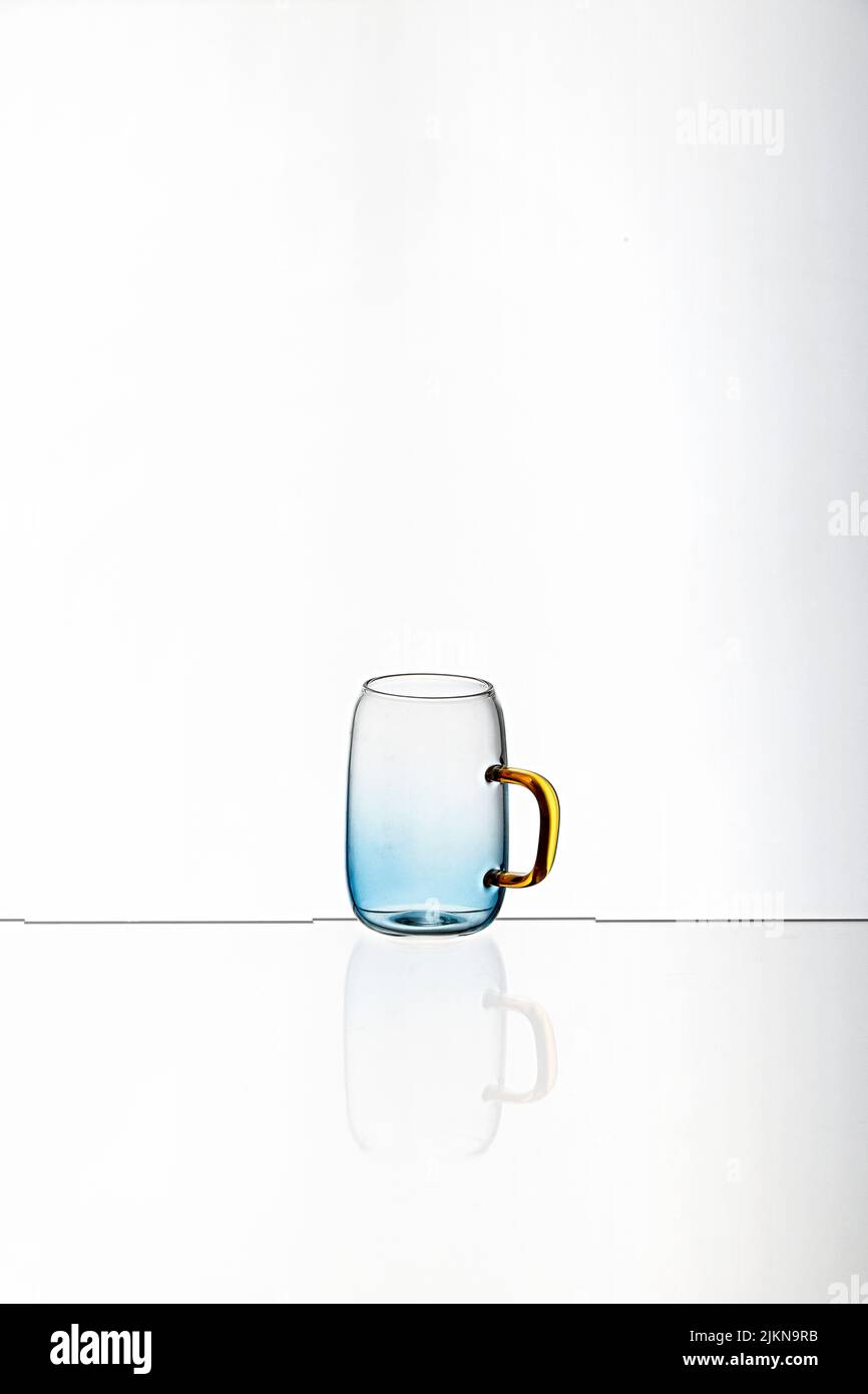 The vertical shot of a glass blue transparent cup with a white ...