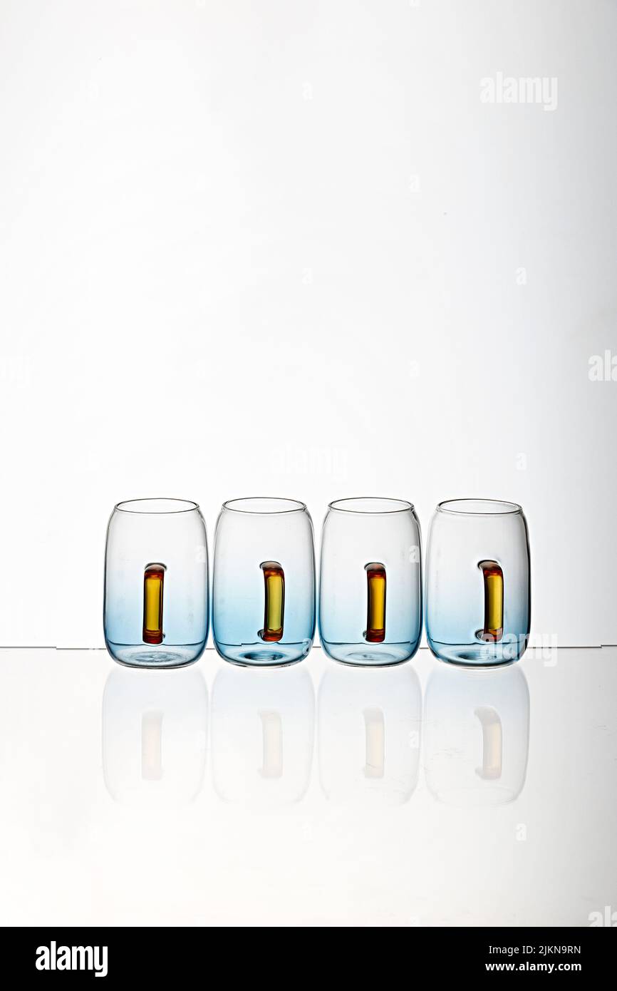 the Vertical shot of a glass blue transparent cups with a white ...