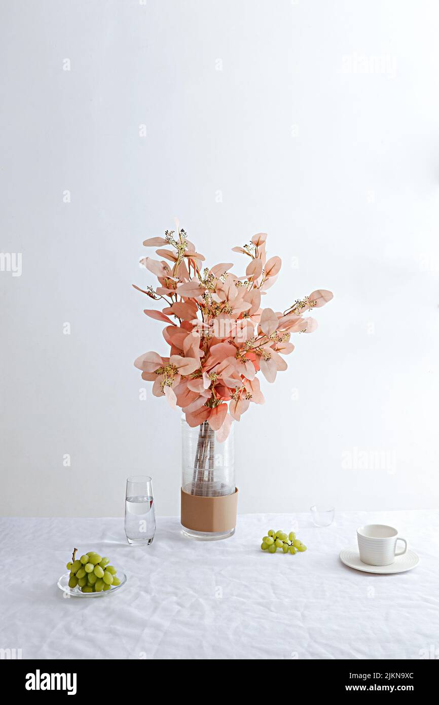 The vertical still life shot of decorative flowers on a vase with a ...