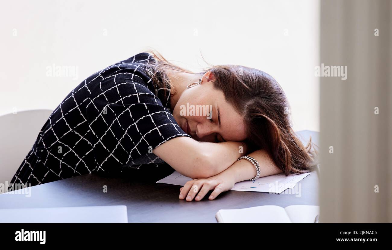 Ill just close my eyes for a bit. a young businesswoman taking a nap in ...
