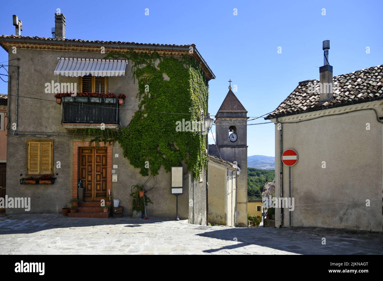 A narrow street in Calvello village with an old tower in the Basilicata ...