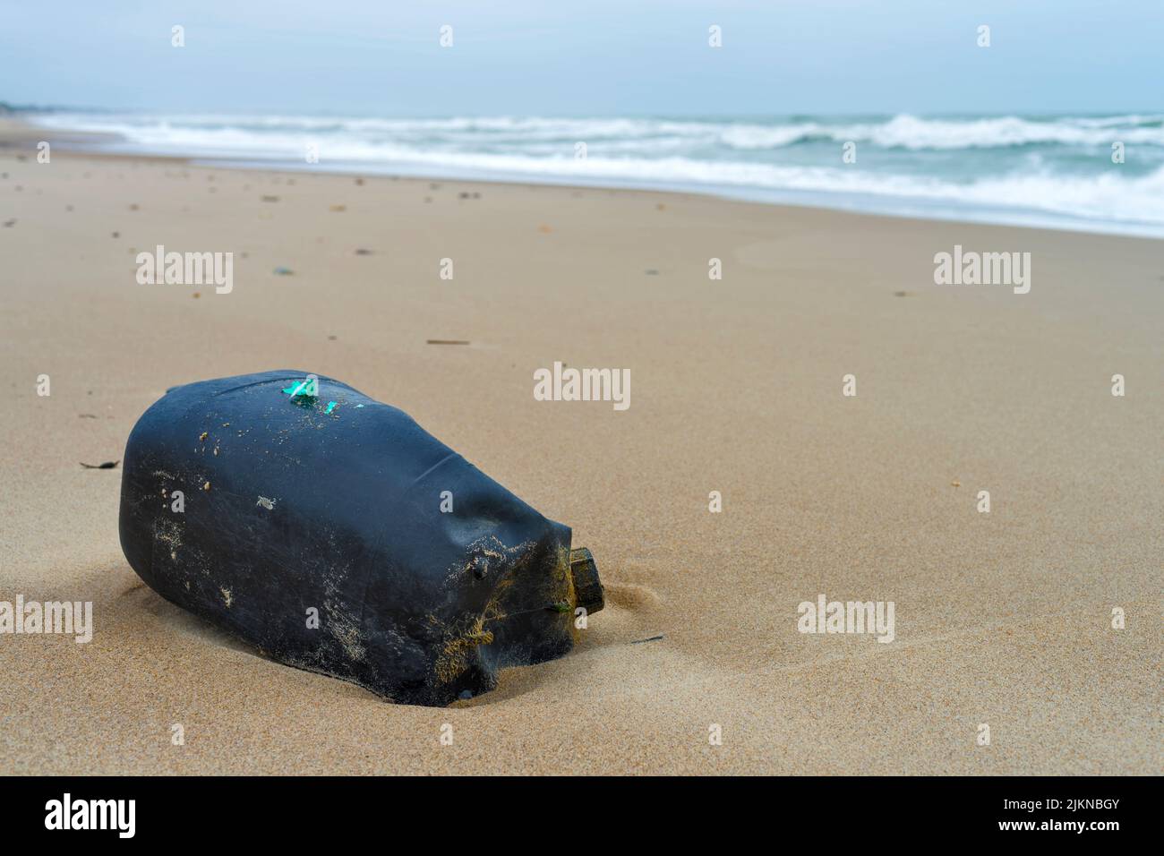 An empty can of oil washed from the sea to the beach Stock Photo - Alamy