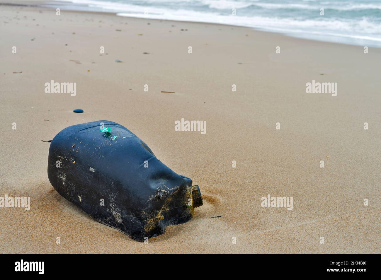 An empty can of oil washed from the sea to the beach Stock Photo - Alamy